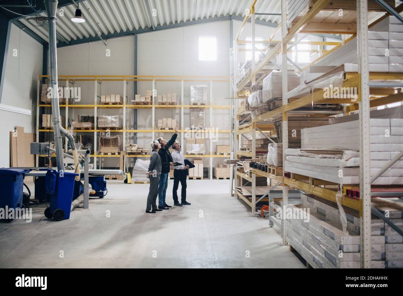 Full length of business people looking at rack in lumber industry Stock ...