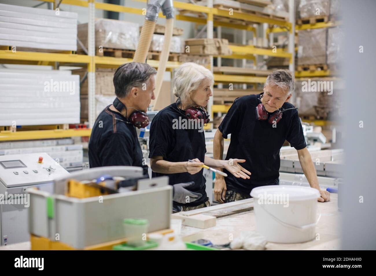 Female workers discussing with colleague while working at industry ...