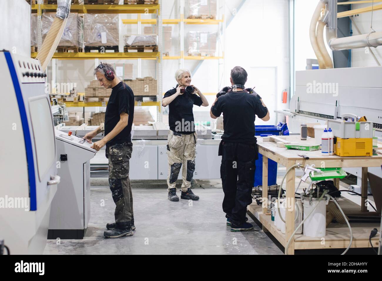 Full length of workers communicating while working at industry Stock ...