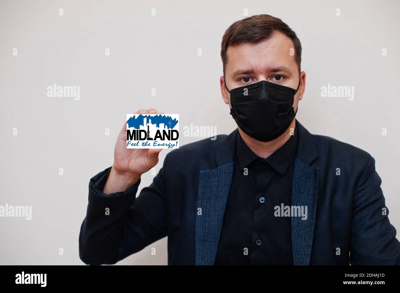 American man wear black formal and protect face mask, hold Midland flag ...