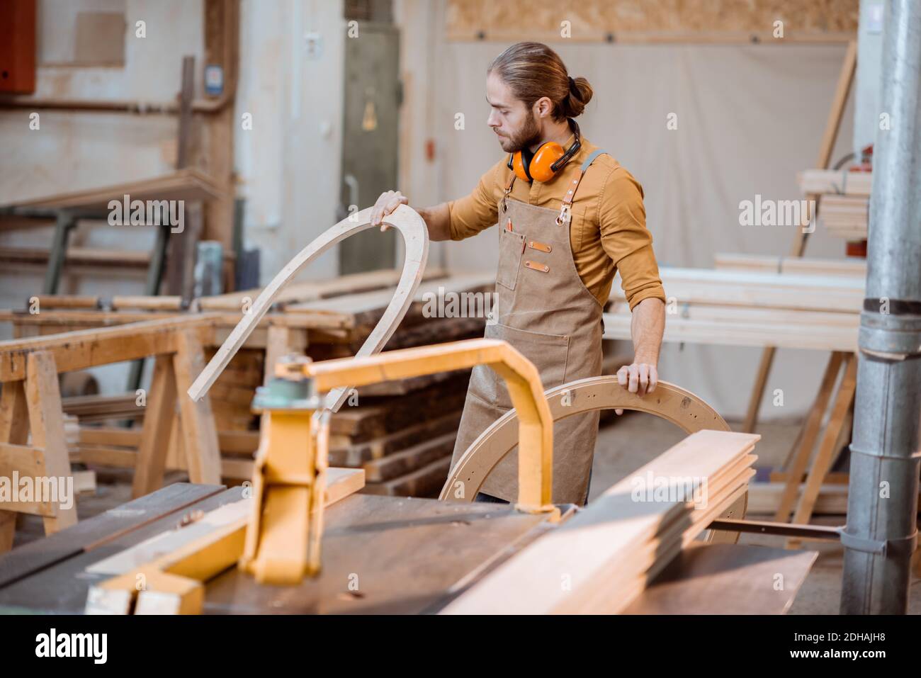 Portrait of a handsome carpenter looking on the wooden product ...