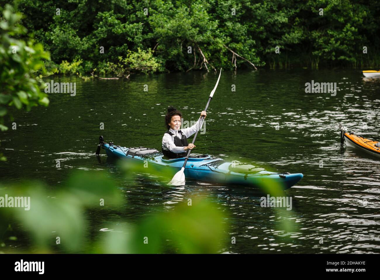 Senior woman paddling kayak in sea during kayaking course Stock Photo ...