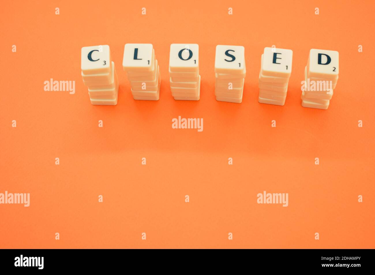 The six white letter block stacks forming the word CLOSED on orange ...
