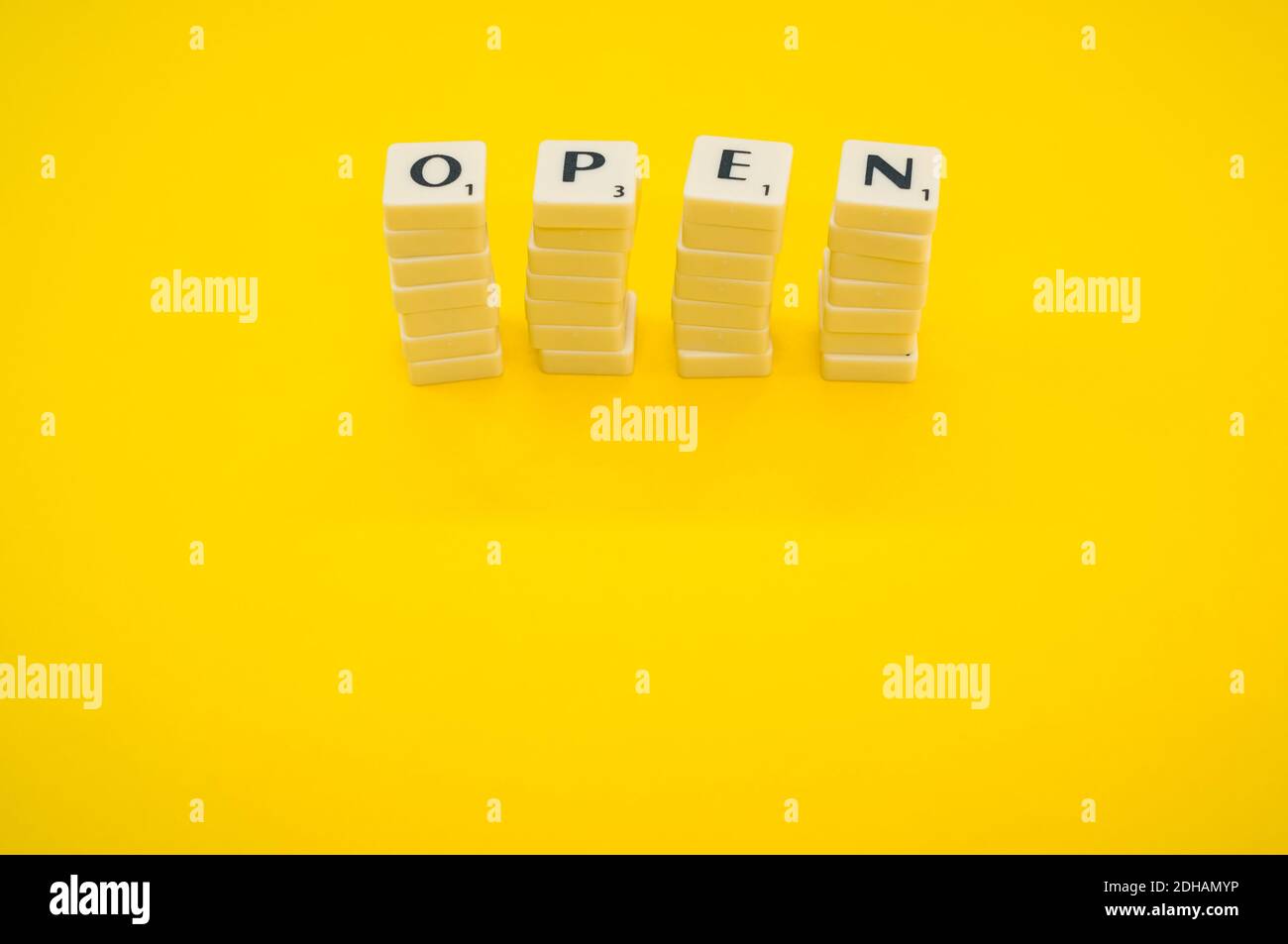 The four white letter block stacks forming the word OPEN on a yellow ...