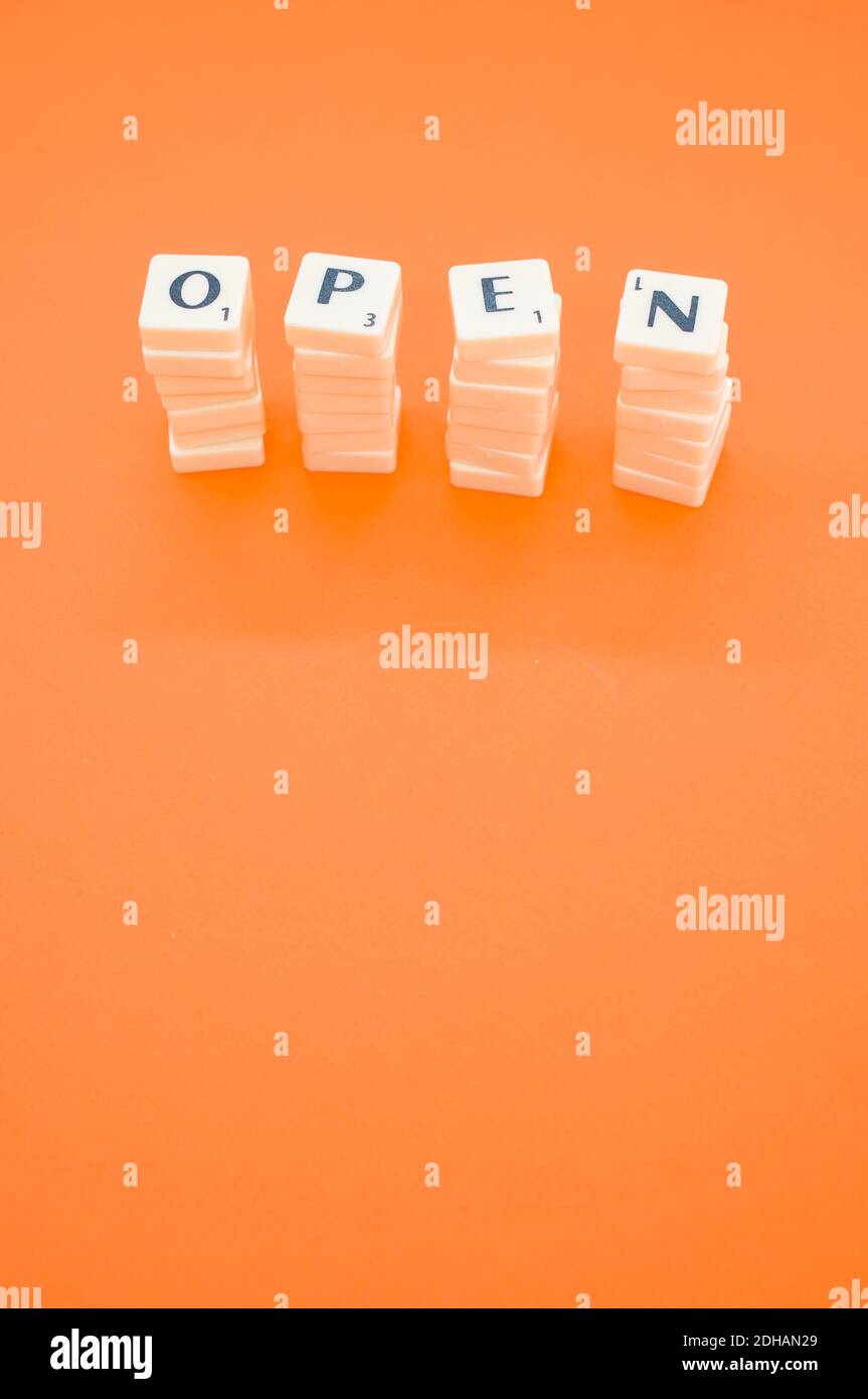 The four white letter block stacks forming the word OPEN on an orange ...
