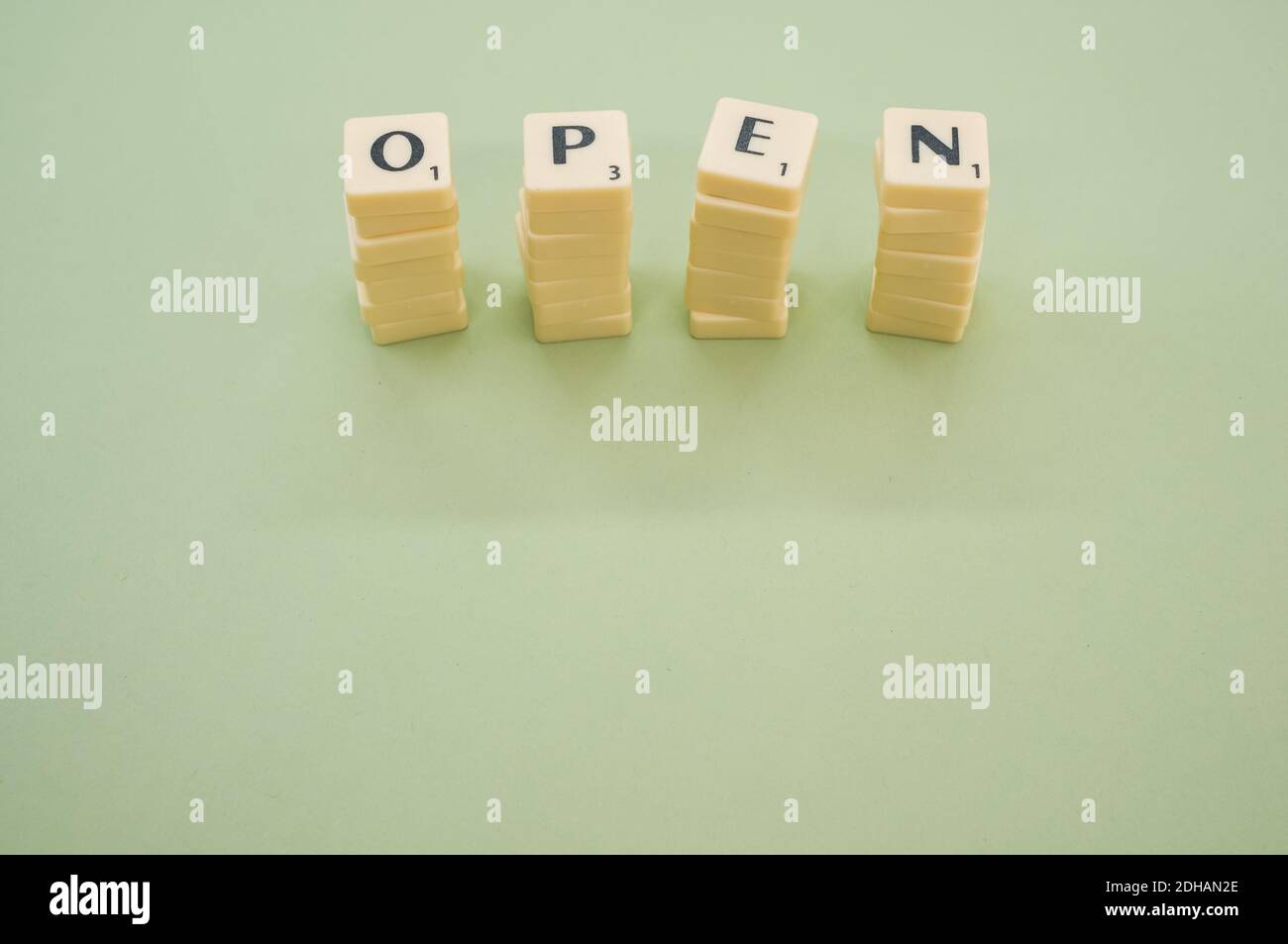 The four white letter block stacks forming the word OPEN on a green ...