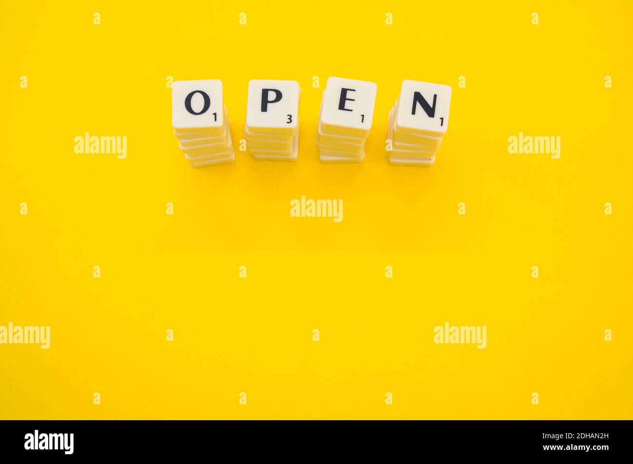 The four white letter block stacks forming the word OPEN on a yellow ...