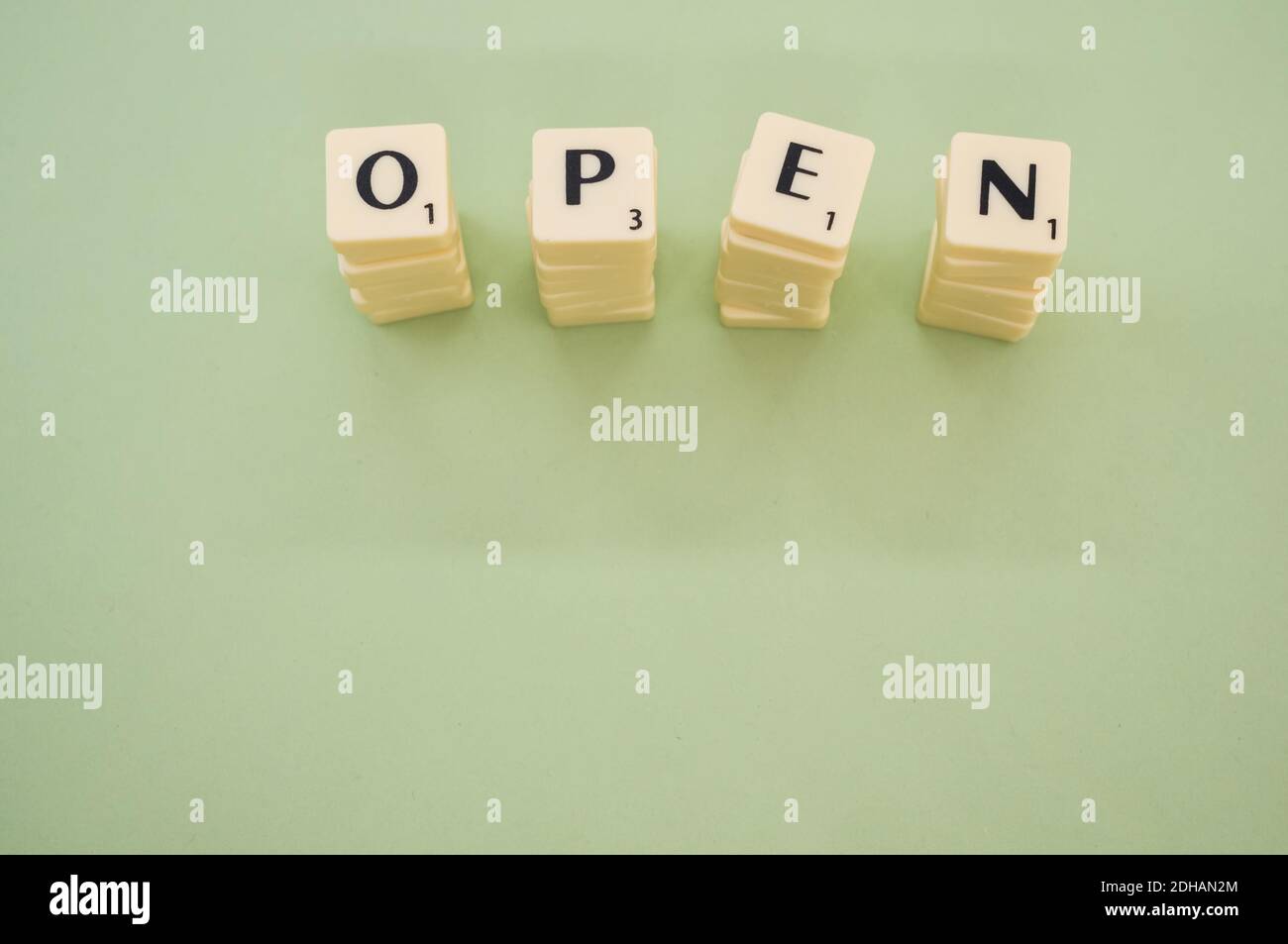 The four white letter block stacks forming the word OPEN on a green ...