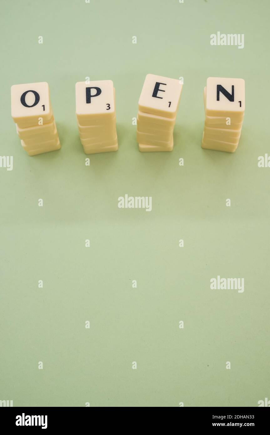 The four white letter block stacks forming the word OPEN on a green ...