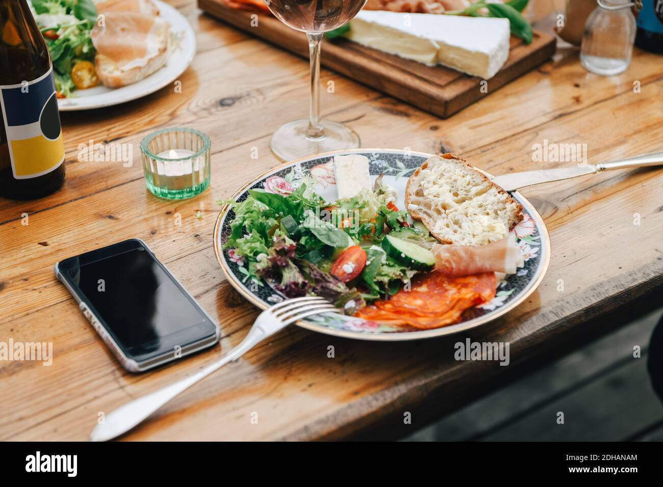 Close-up of healthy food served in plate by mobile phone on table ...