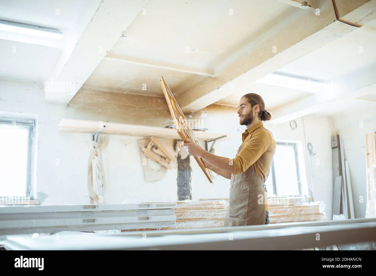 Handsome carpenter checking the quality of the window frame before the ...