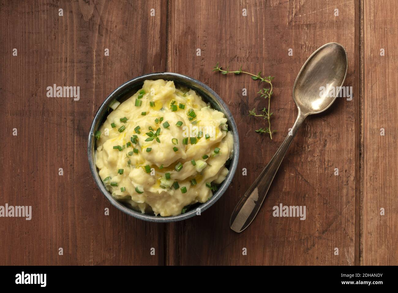 Pomme puree, an overhead photo of a bowl of mashed potatoes with herbs ...