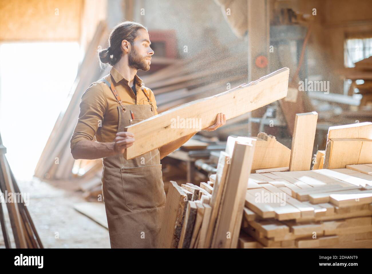Carpenter or warehouse worker choosing raw wood material for the work ...