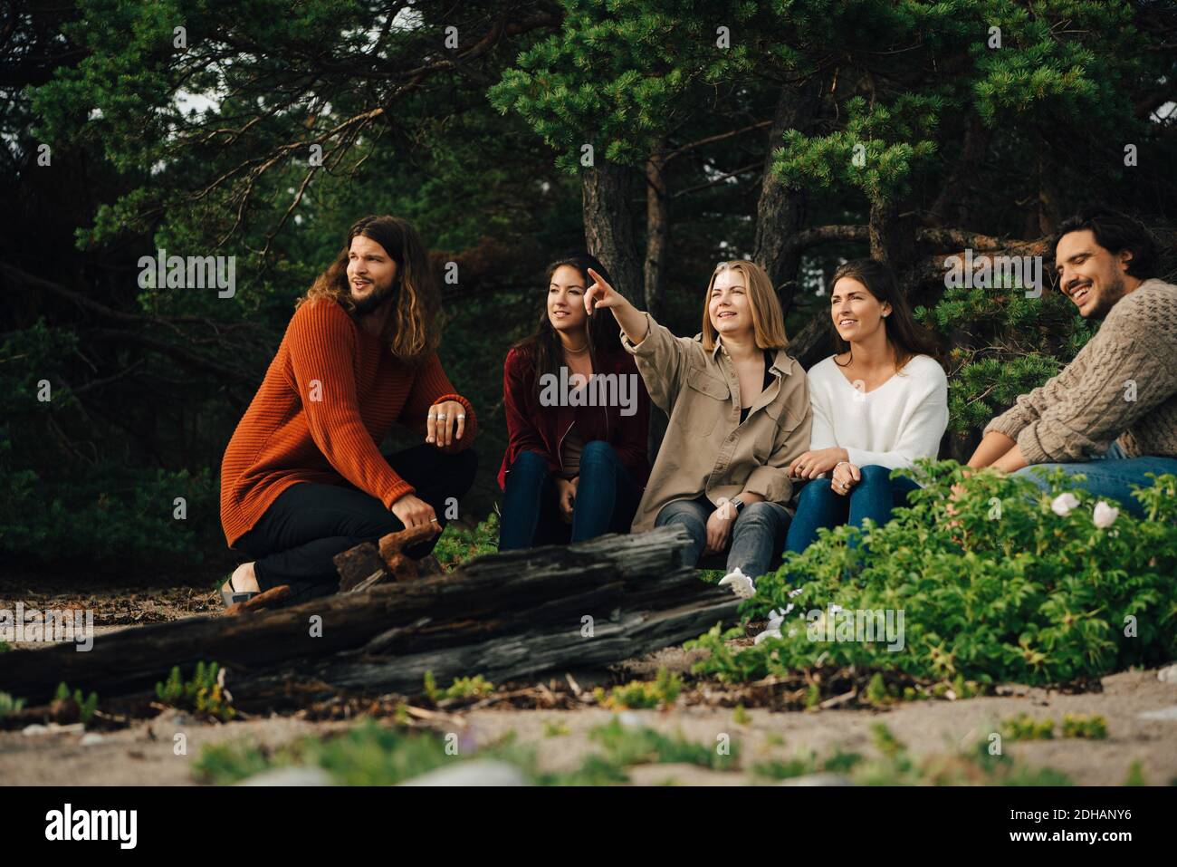 Woman pointing while showing to friends at beach Stock Photo - Alamy