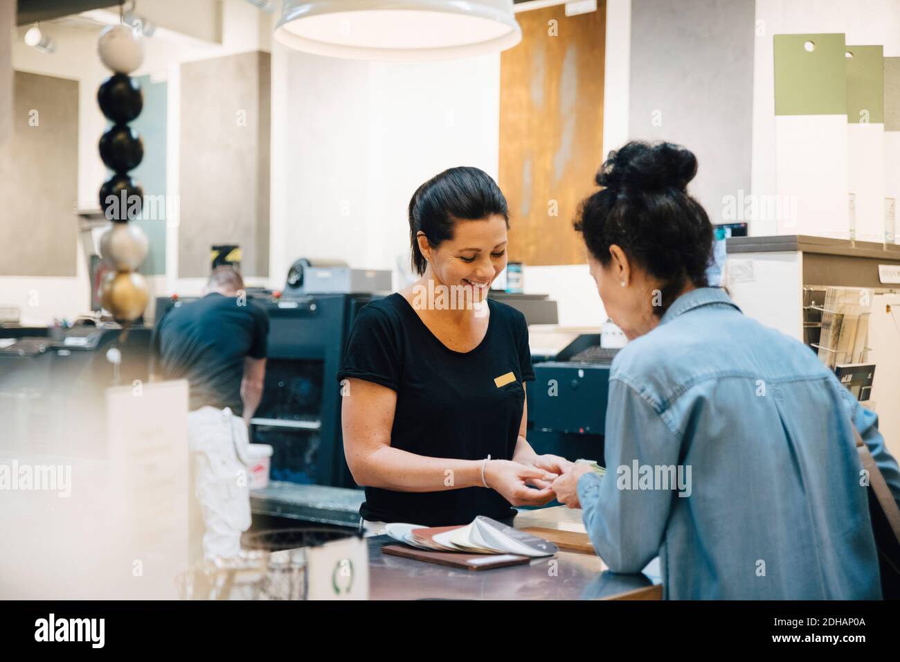 Sales person assisting female customer at hardware store Stock Photo ...