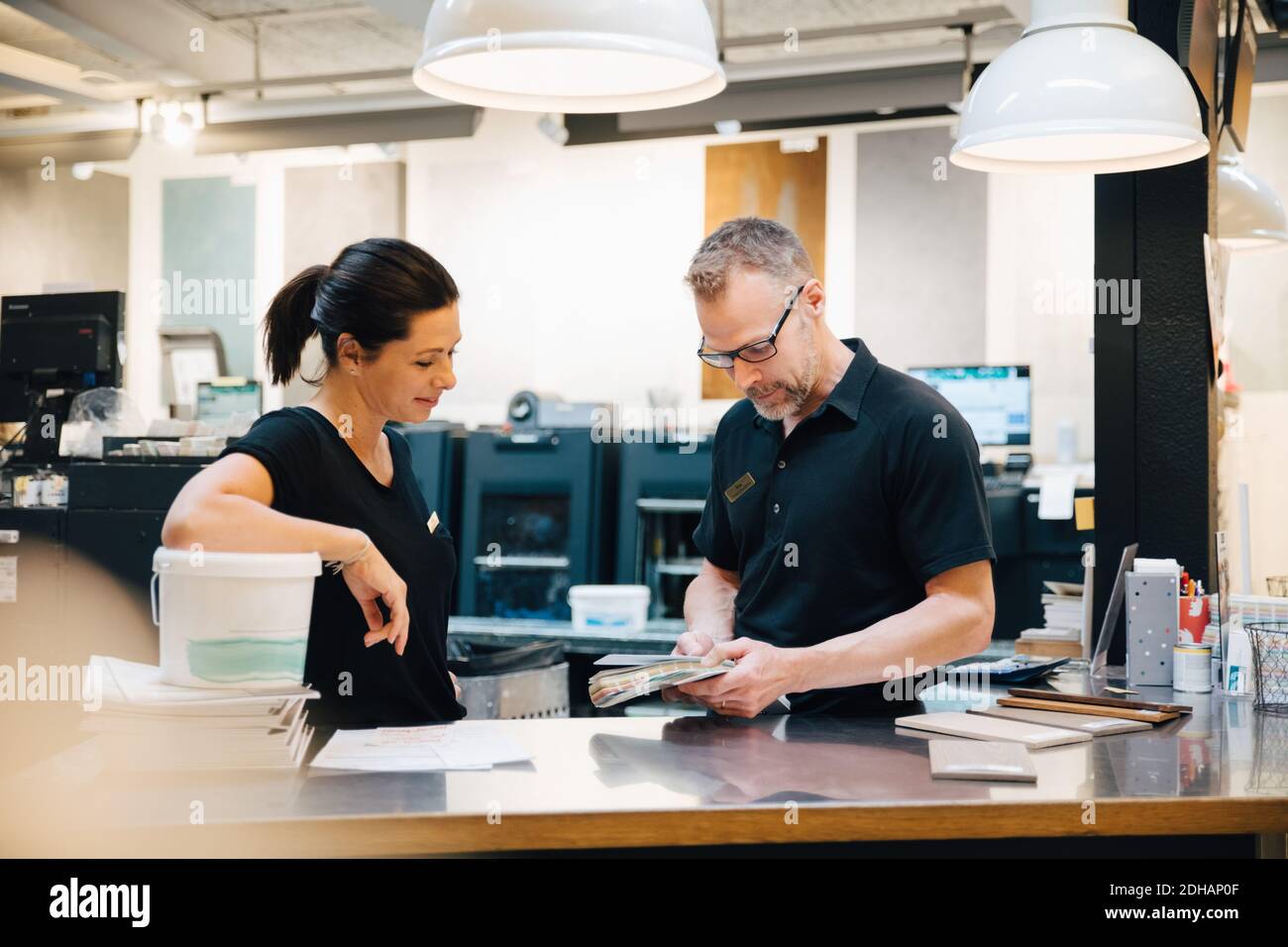Male and female employees working at hardware store Stock Photo - Alamy