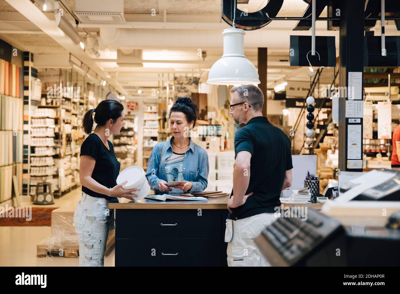 Female customer talking with sales employees at hardware store Stock ...