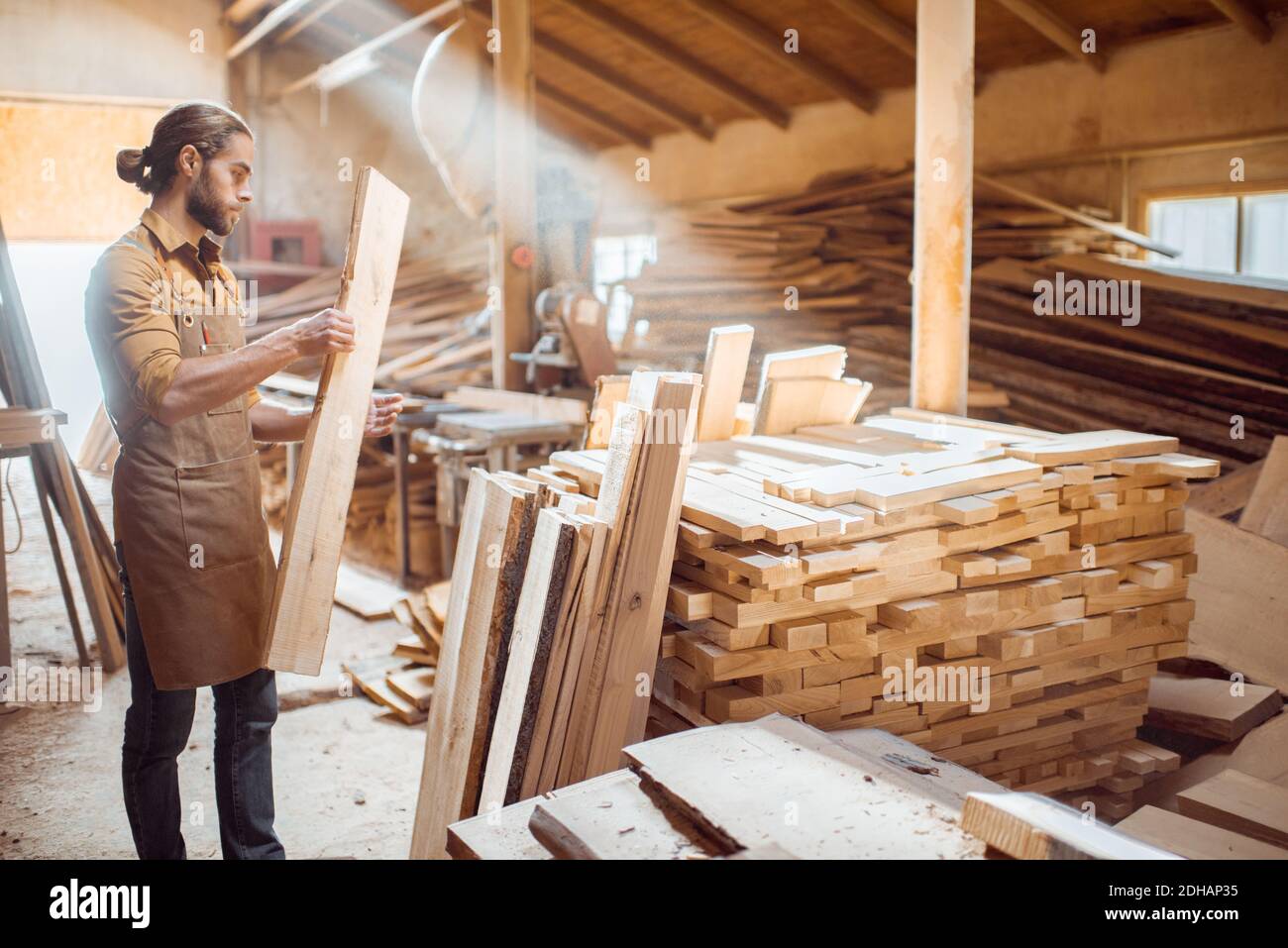 Carpenter or warehouse worker choosing raw wood material for the work ...
