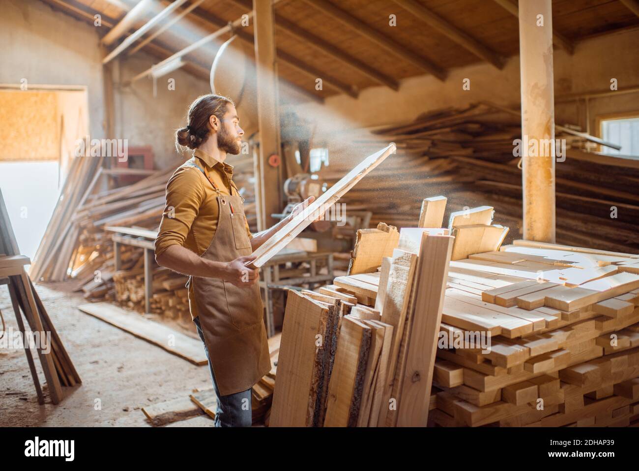 Carpenter or warehouse worker choosing raw wood material for the work ...