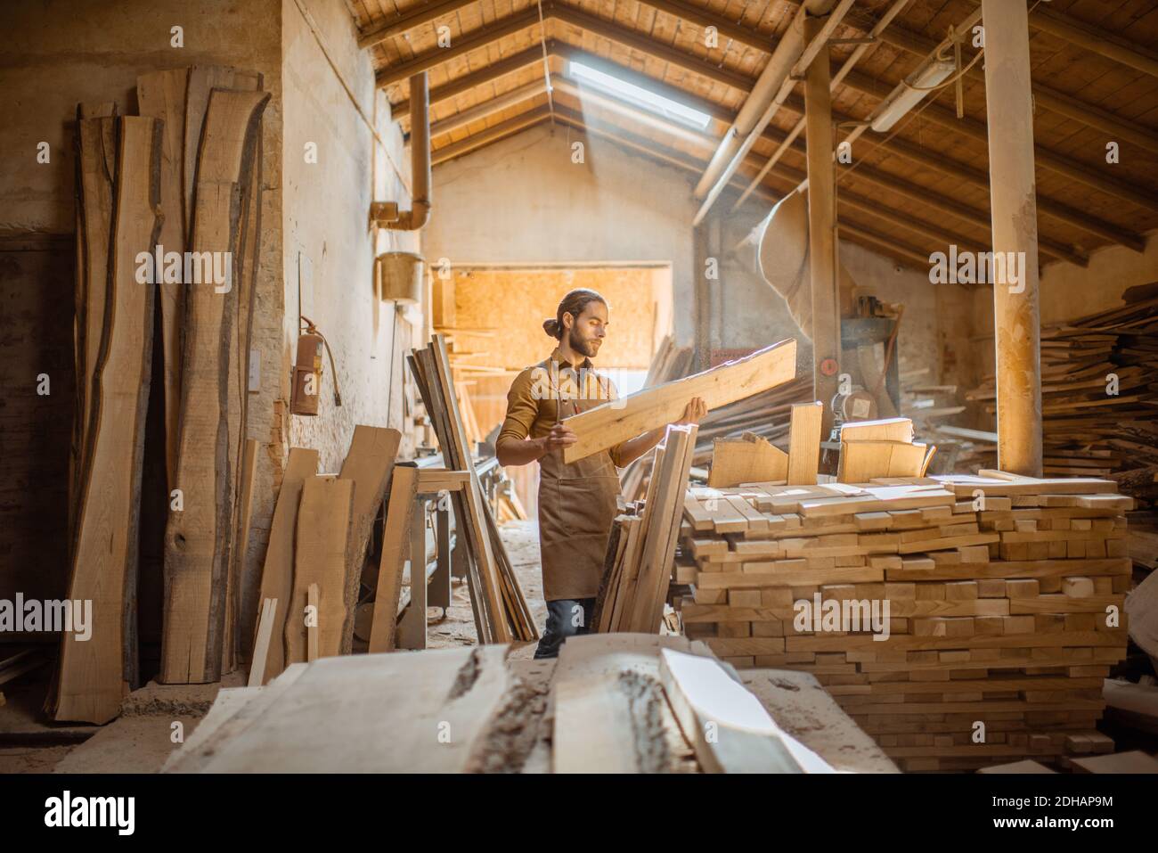 Carpenter or warehouse worker choosing raw wood material for the work ...