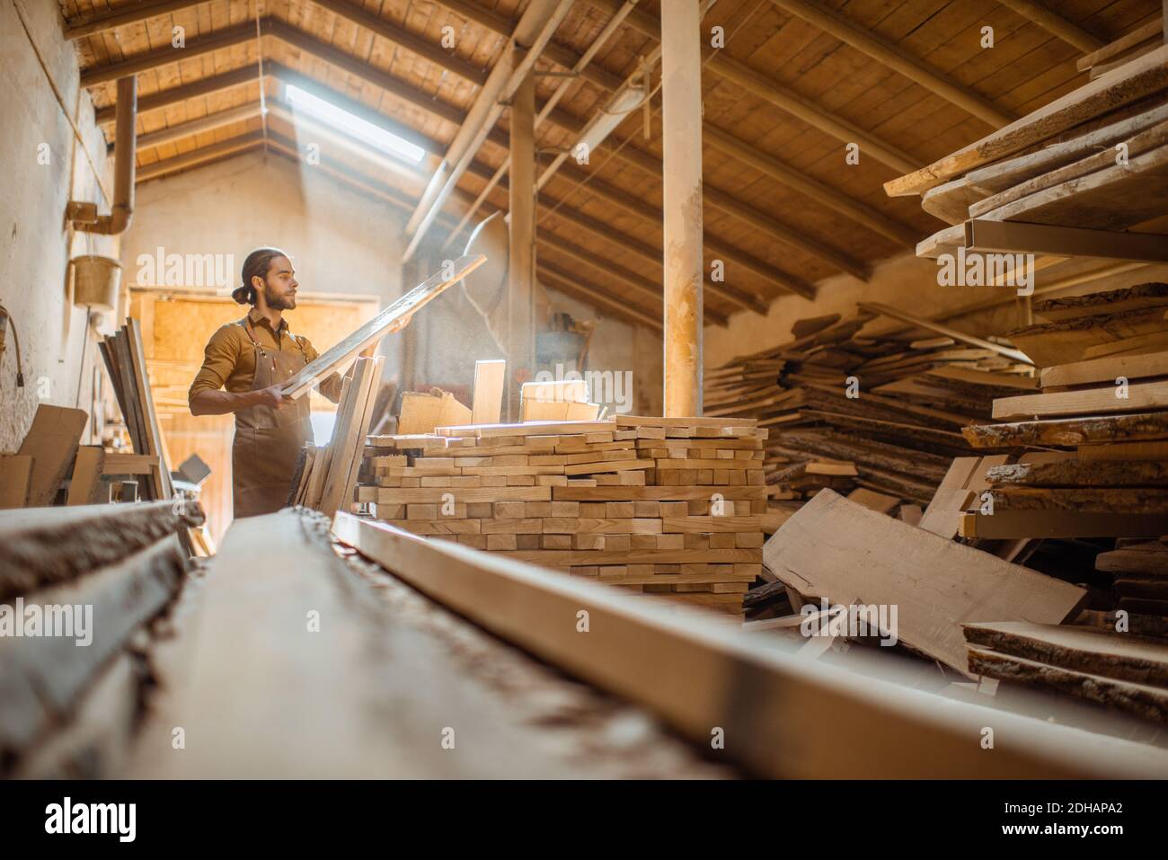 Carpenter or warehouse worker choosing raw wood material for the work ...