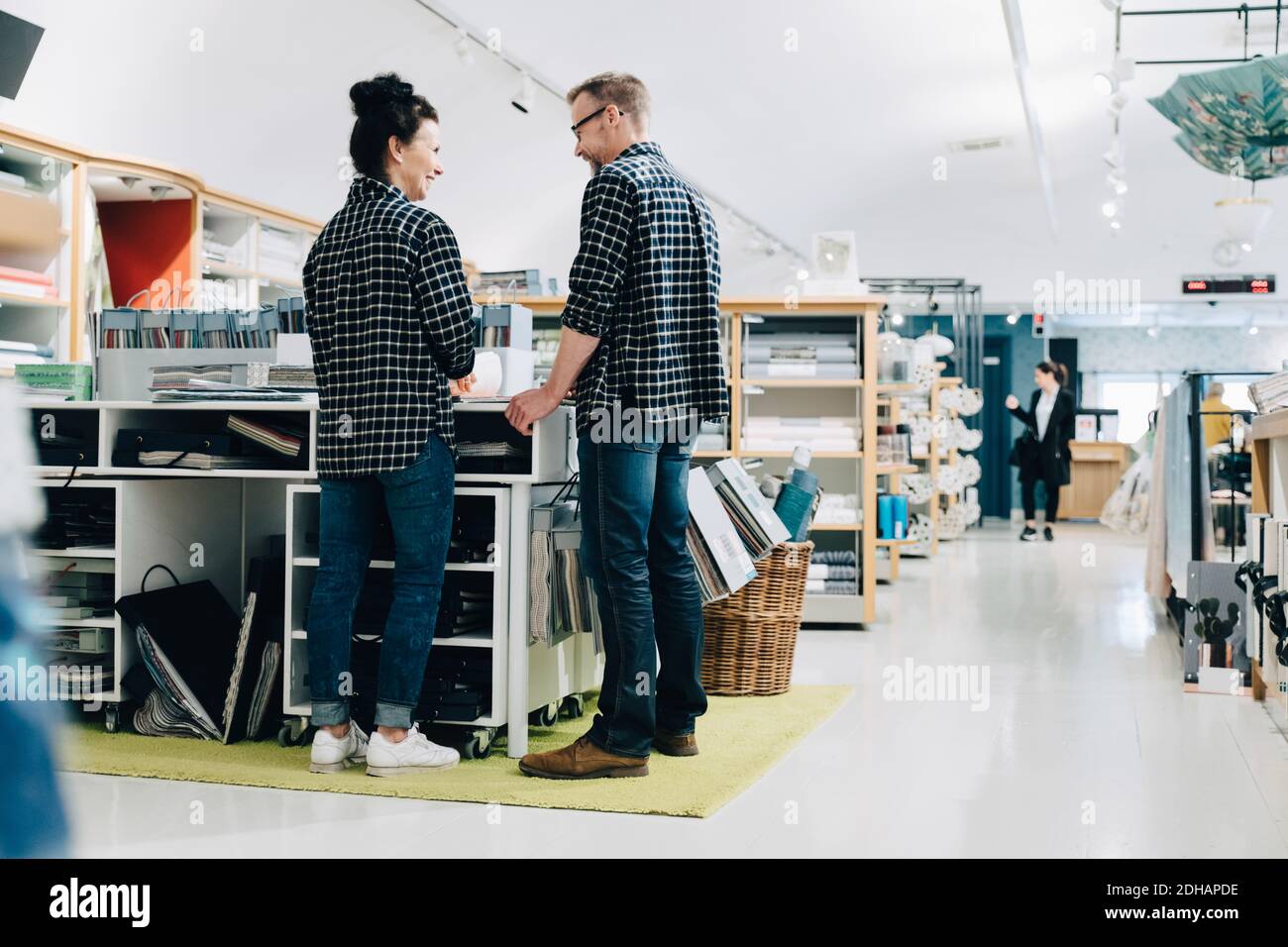 Full length of smiling coworkers working in store Stock Photo - Alamy