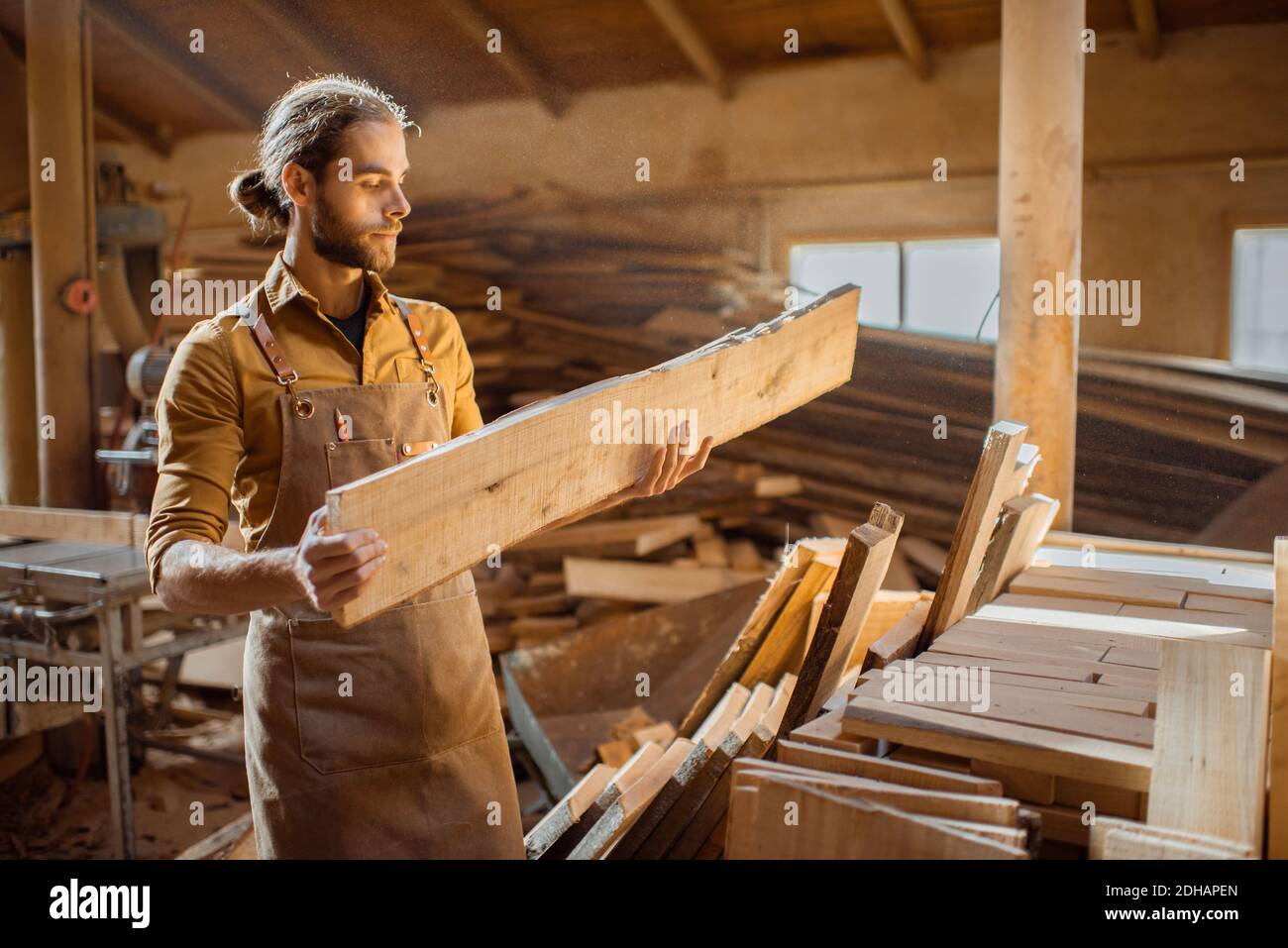 Carpenter or warehouse worker choosing raw wood material for the work ...