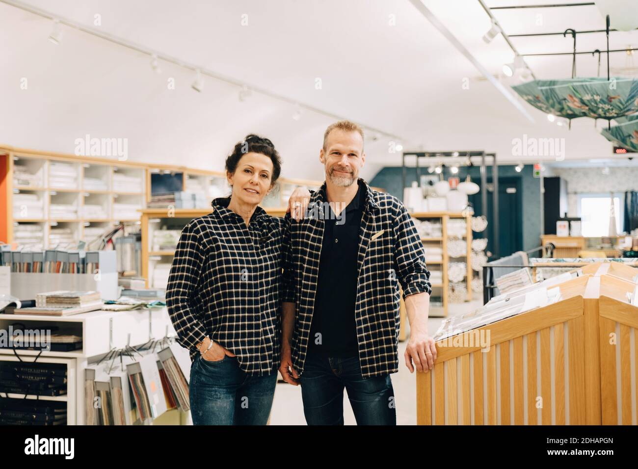 Portrait of smiling male and female employees standing in store Stock ...