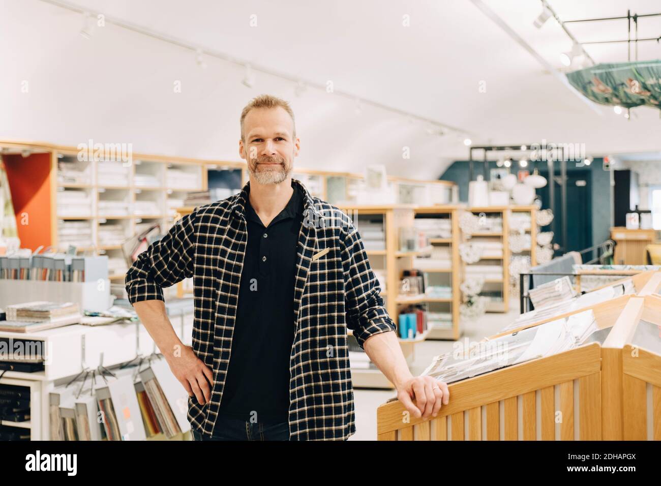 Portrait of smiling salesman standing in store Stock Photo - Alamy