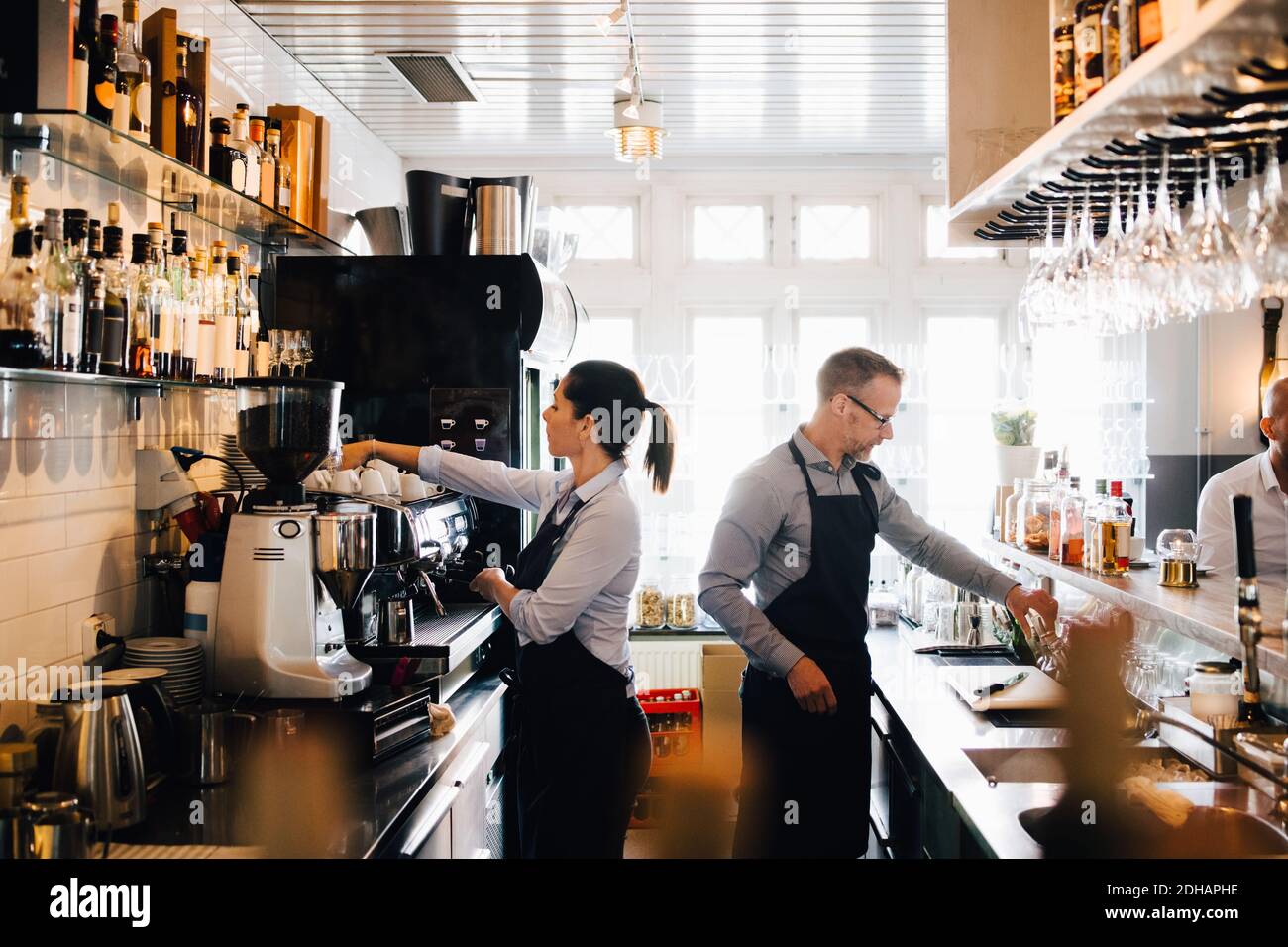 Male and female coworkers working in kitchen at restaurant Stock Photo ...