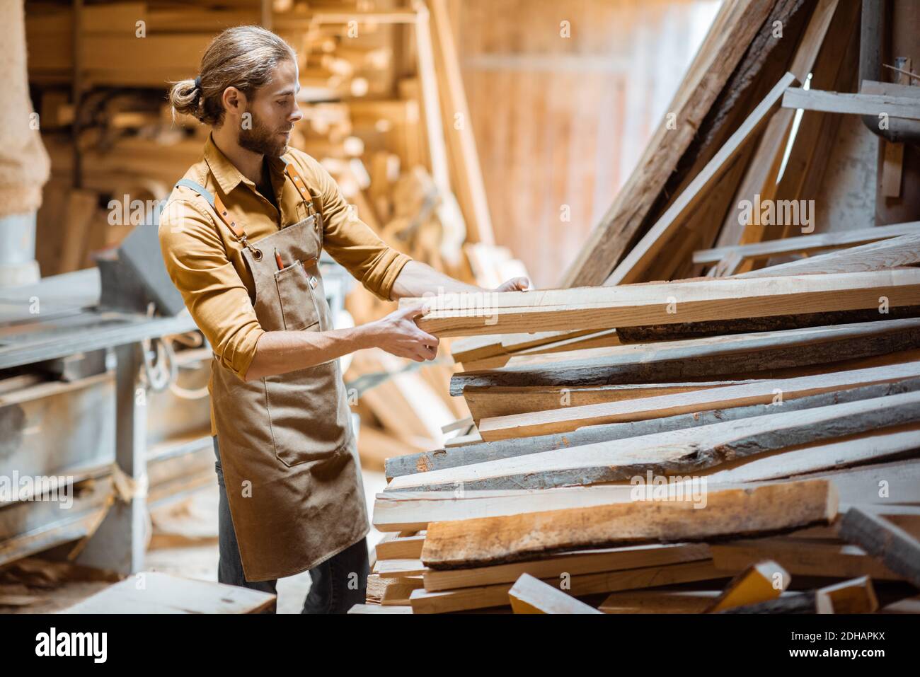 Carpenter or warehouse worker choosing raw wood material for the work ...