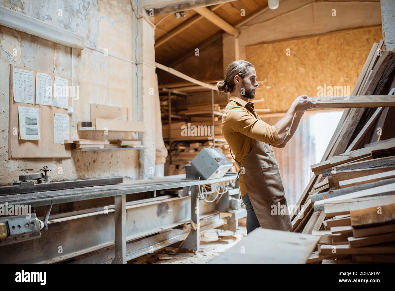 Carpenter or warehouse worker choosing raw wood material for the work ...