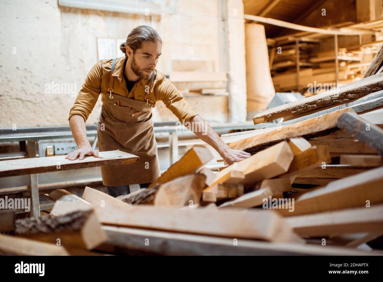 Carpenter or warehouse worker choosing raw wood material for the work ...
