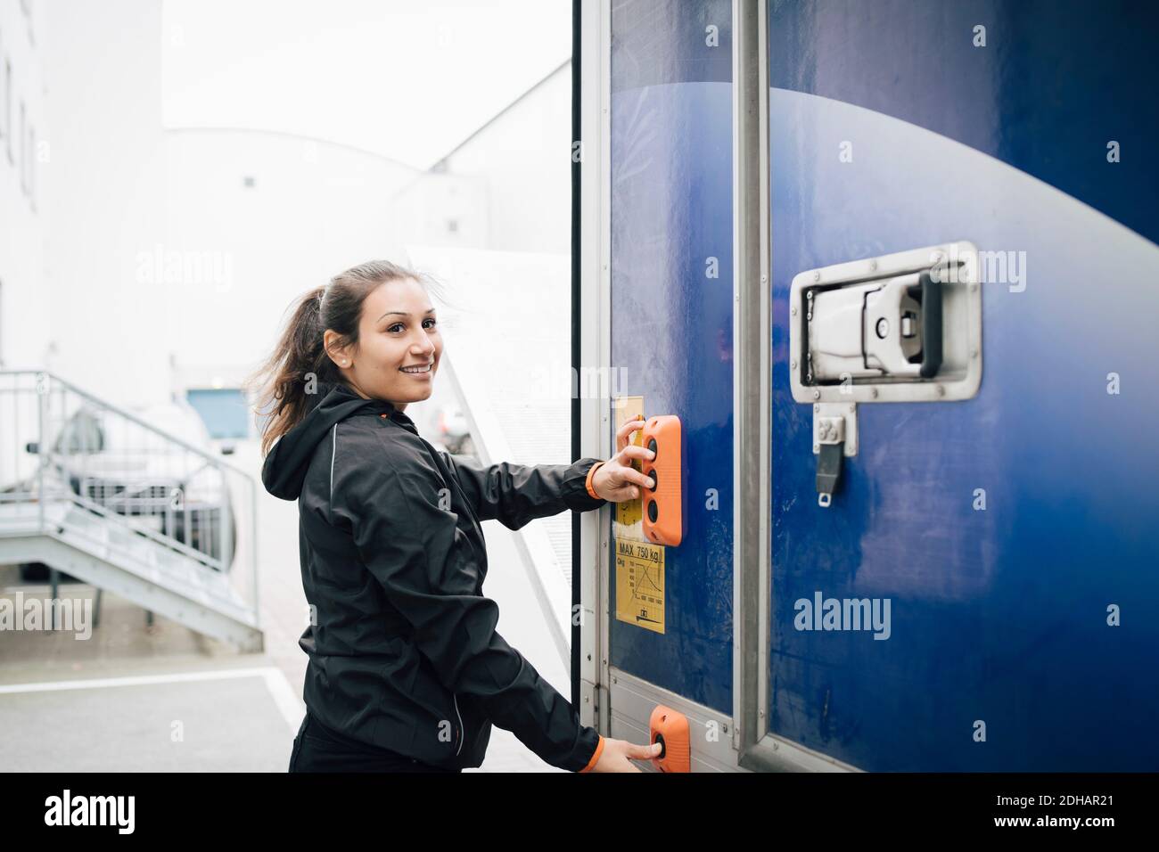 Smiling woman pushing buttons on delivery van Stock Photo - Alamy