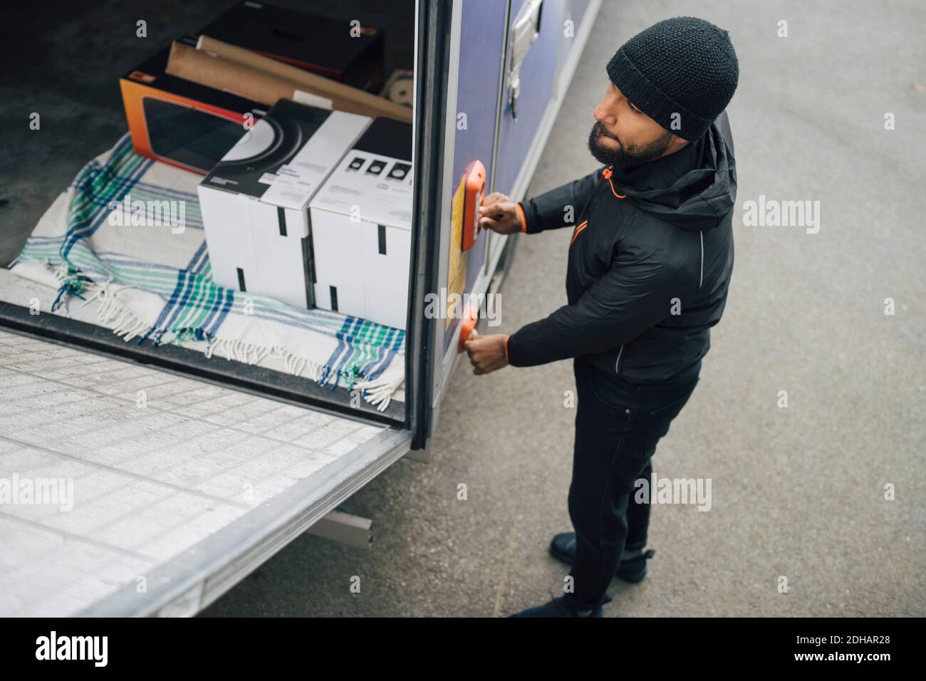 High angle view of worker opening van trunk by pushing buttons on ...