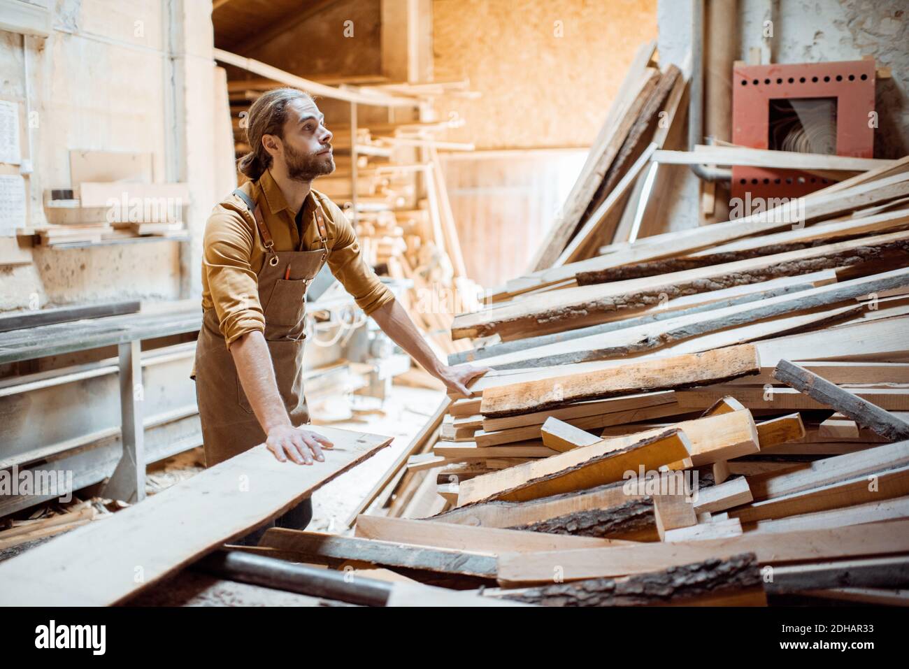 Carpenter or warehouse worker choosing raw wood material for the work ...