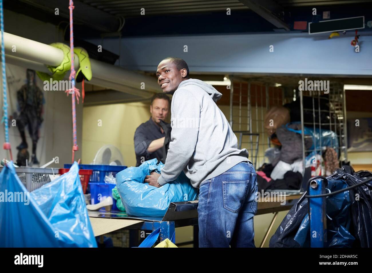 Male volunteers working at workbench in warehouse Stock Photo - Alamy