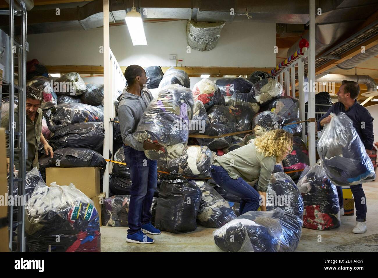 Colleagues stacking plastic sacks in warehouse Stock Photo - Alamy