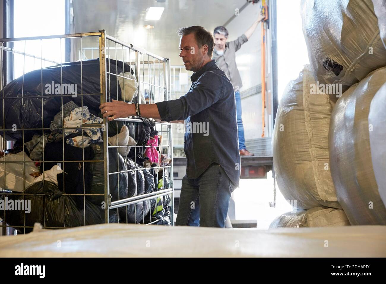 Mature volunteer unloading semi-truck at warehouse Stock Photo - Alamy
