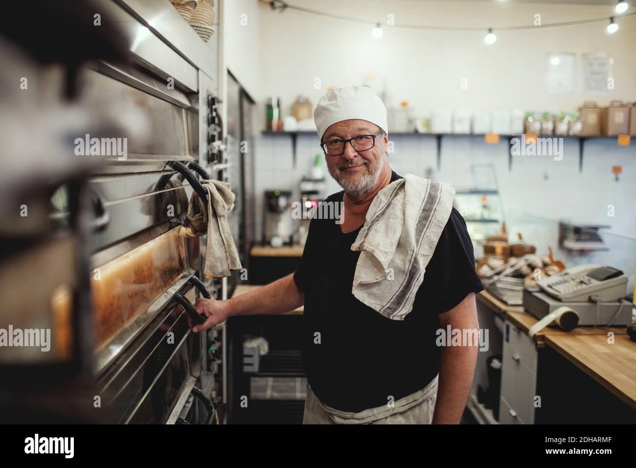 Portrait of senior baker standing by oven at bakery Stock Photo - Alamy