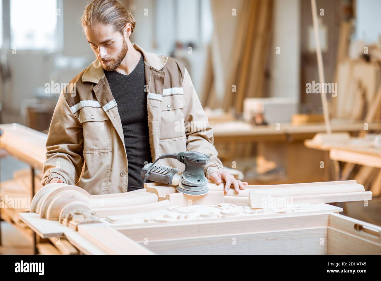 Handsome carpenter checks out carving quality of a joiner's product at ...