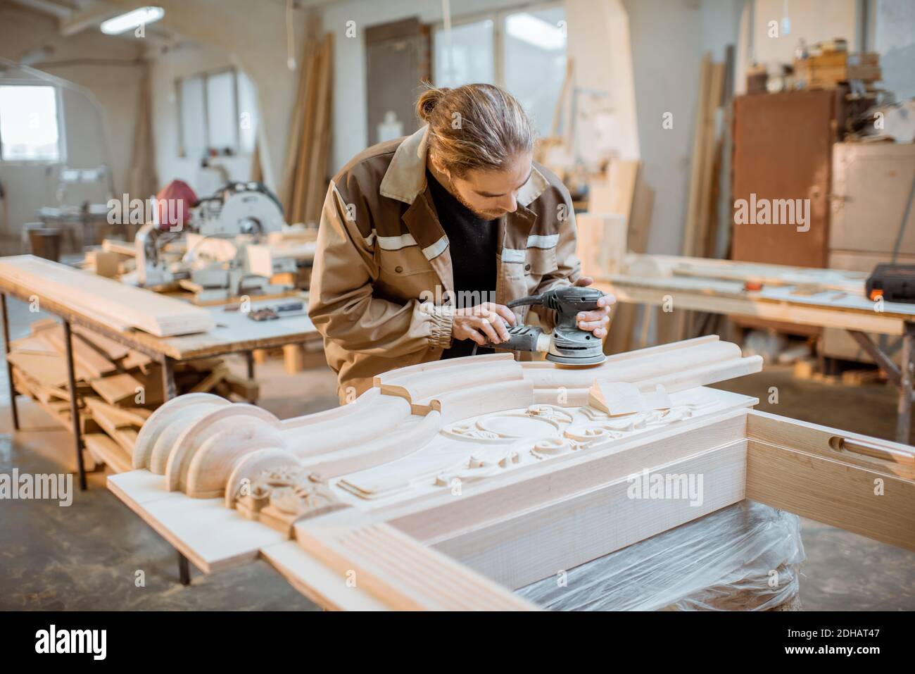 Carpenter grinding joinery product with carvings, finishing woodwork at ...