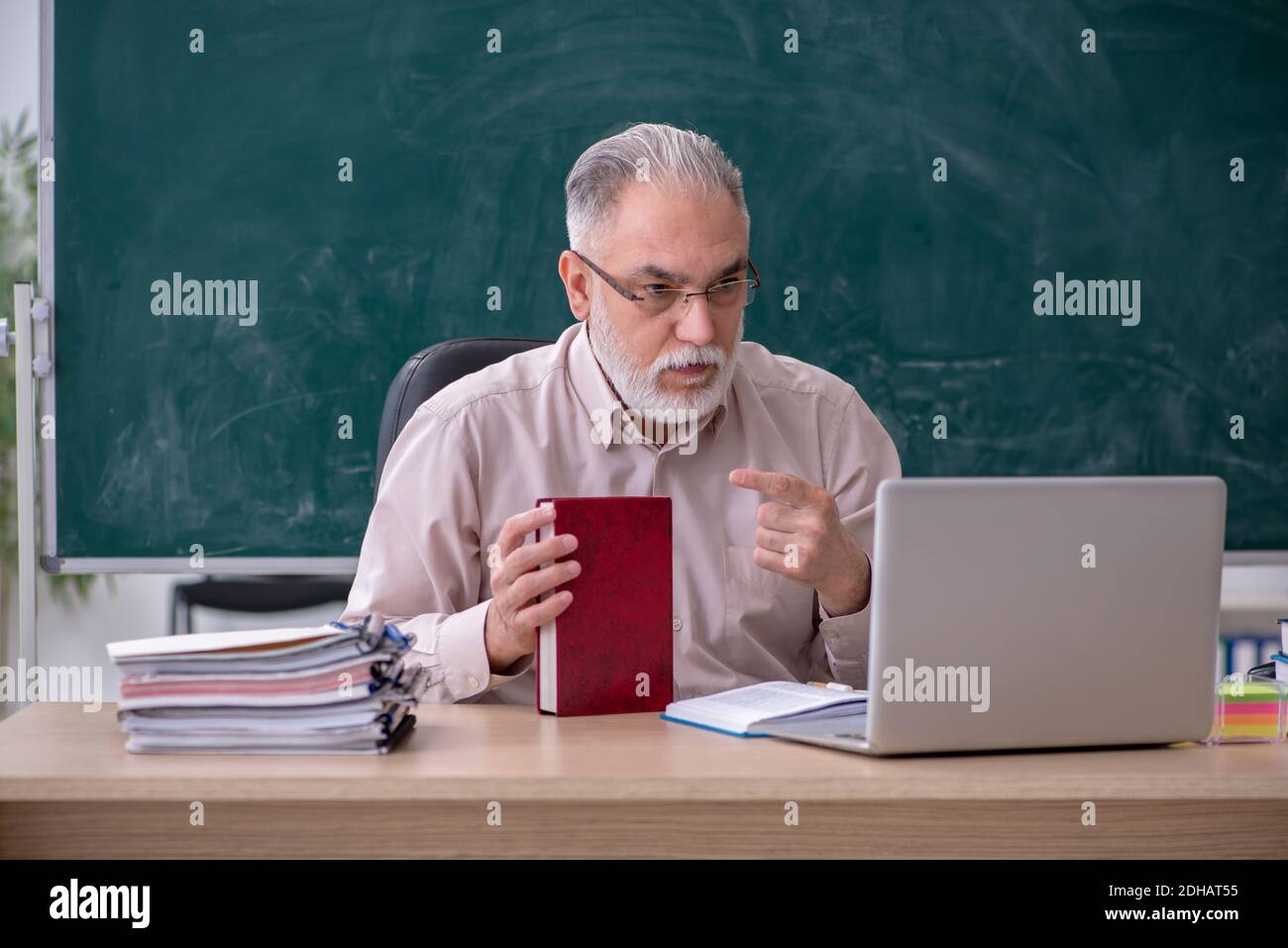 Old male teacher sitting in the classroom Stock Photo - Alamy