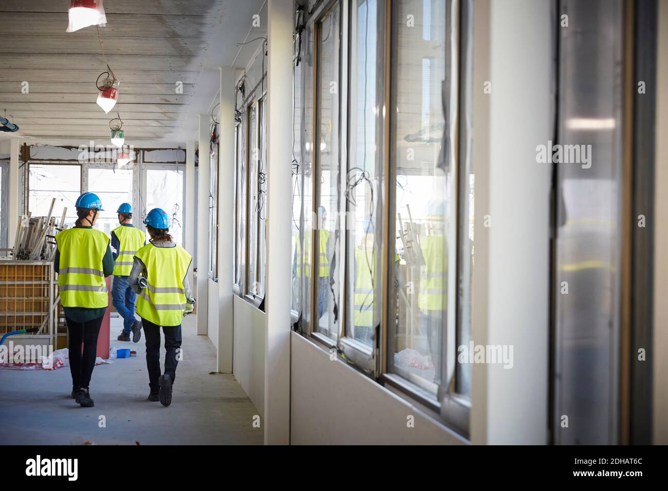 Rear view of female coworkers walking at construction site Stock Photo ...