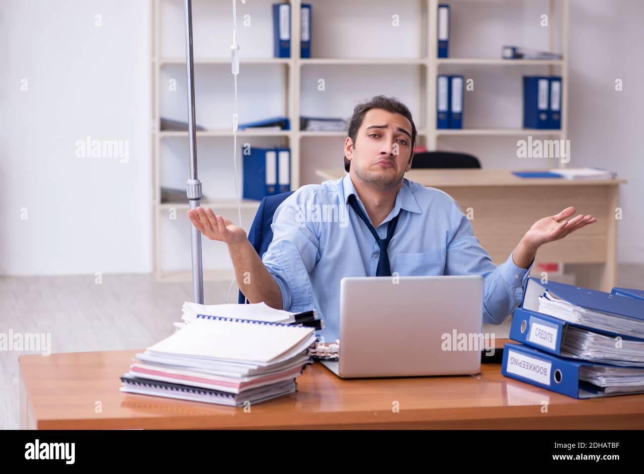 Young male employee suffering at workplace Stock Photo - Alamy