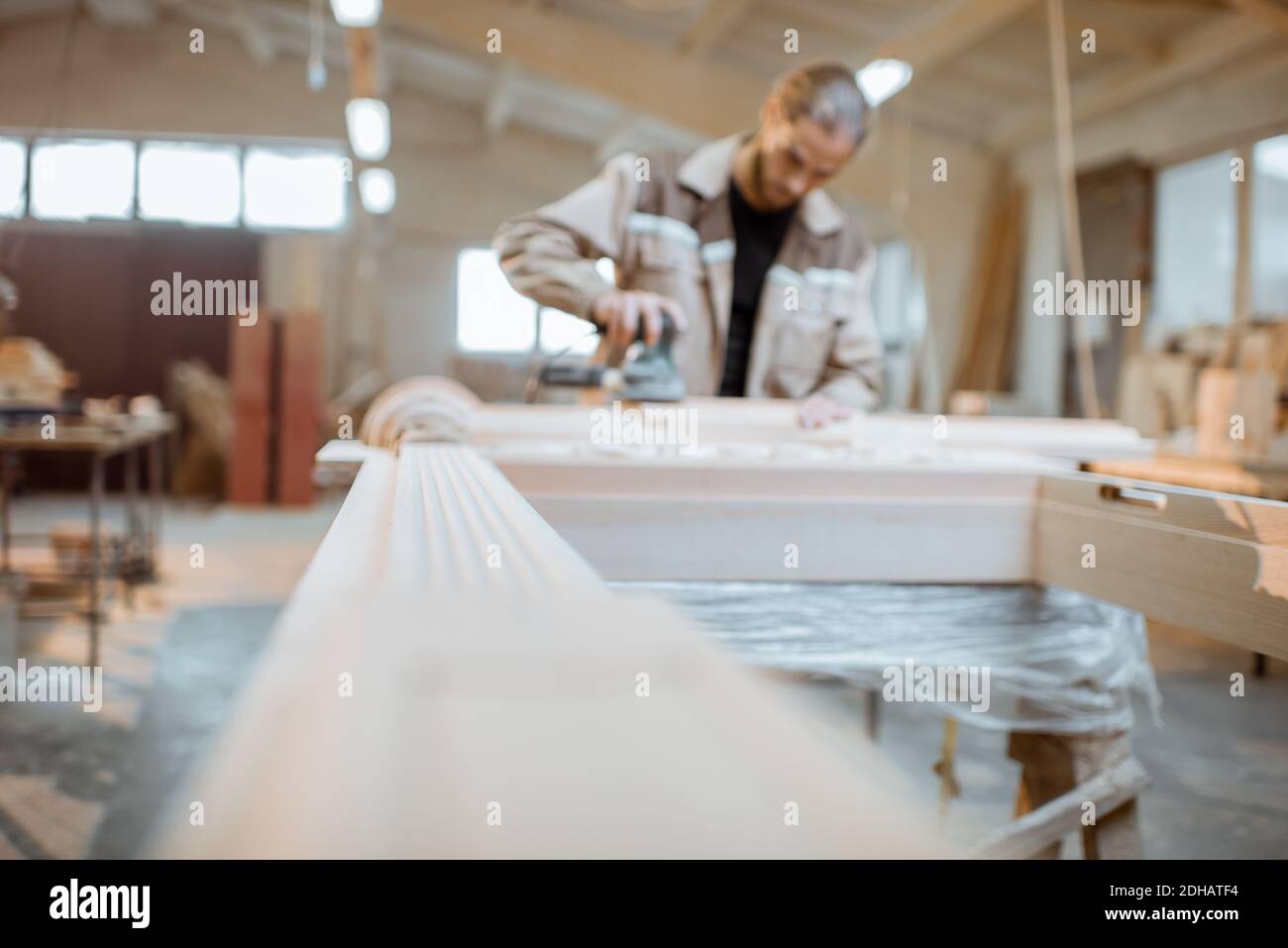 Carpenter grinding joinery product with carvings, finishing woodwork at ...