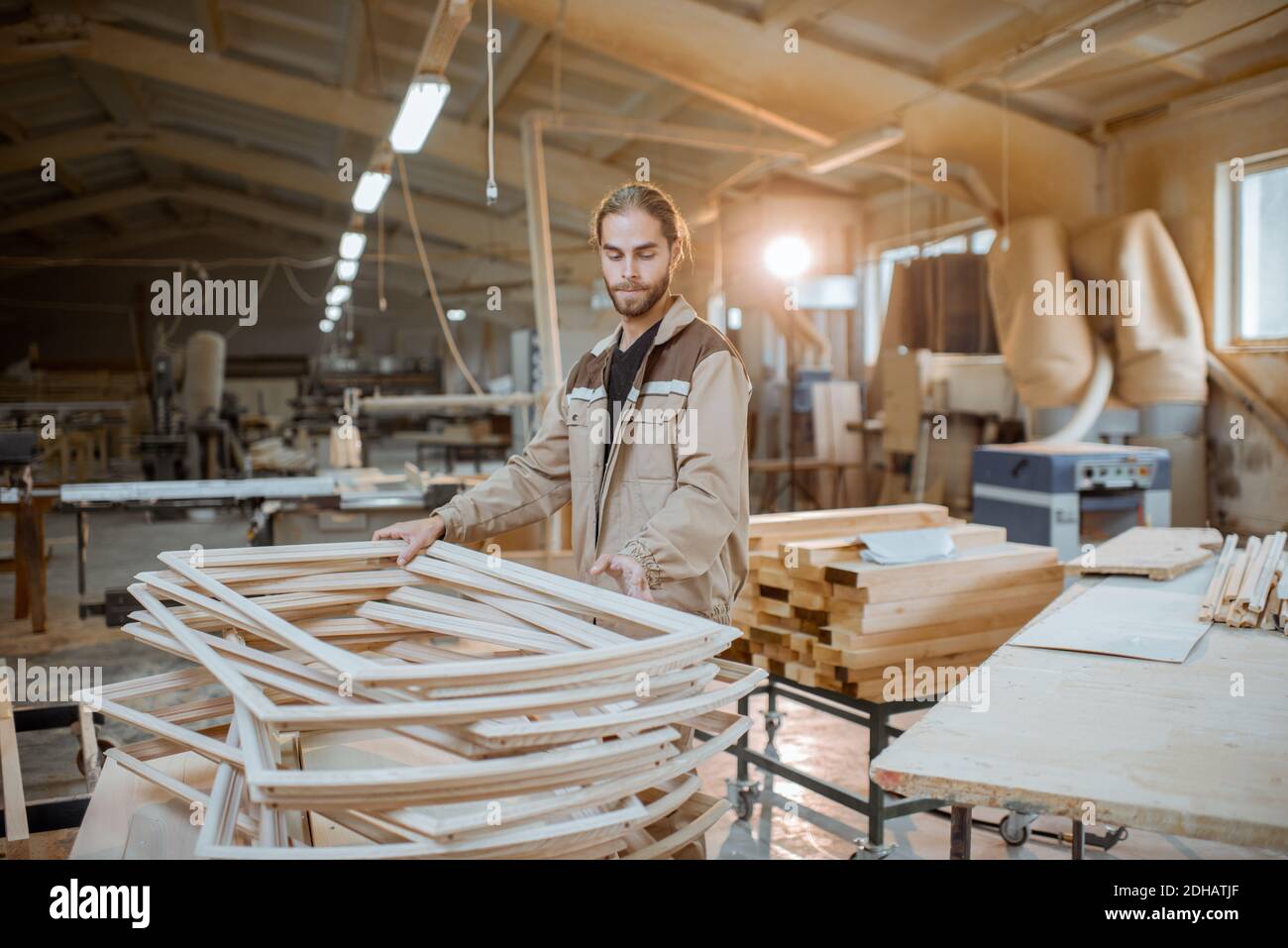 Handsome carpenter checking the quality of the window frame before the ...
