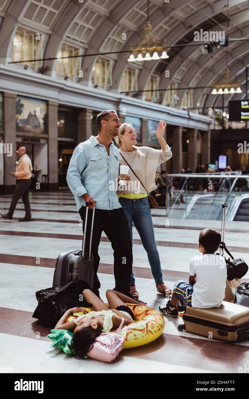 Bored family with luggage waiting at train station Stock Photo - Alamy
