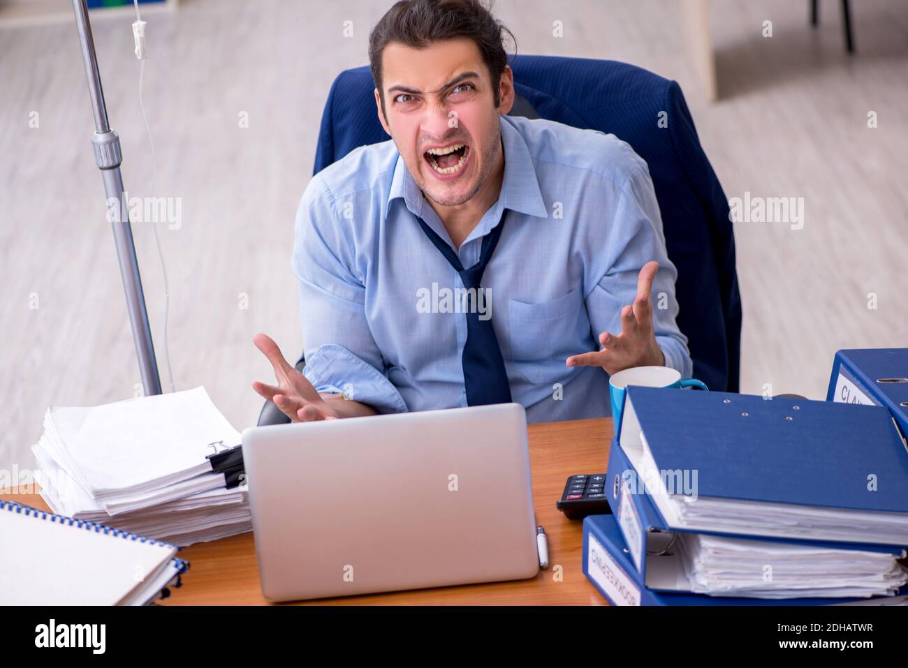 Young male employee suffering at workplace Stock Photo - Alamy