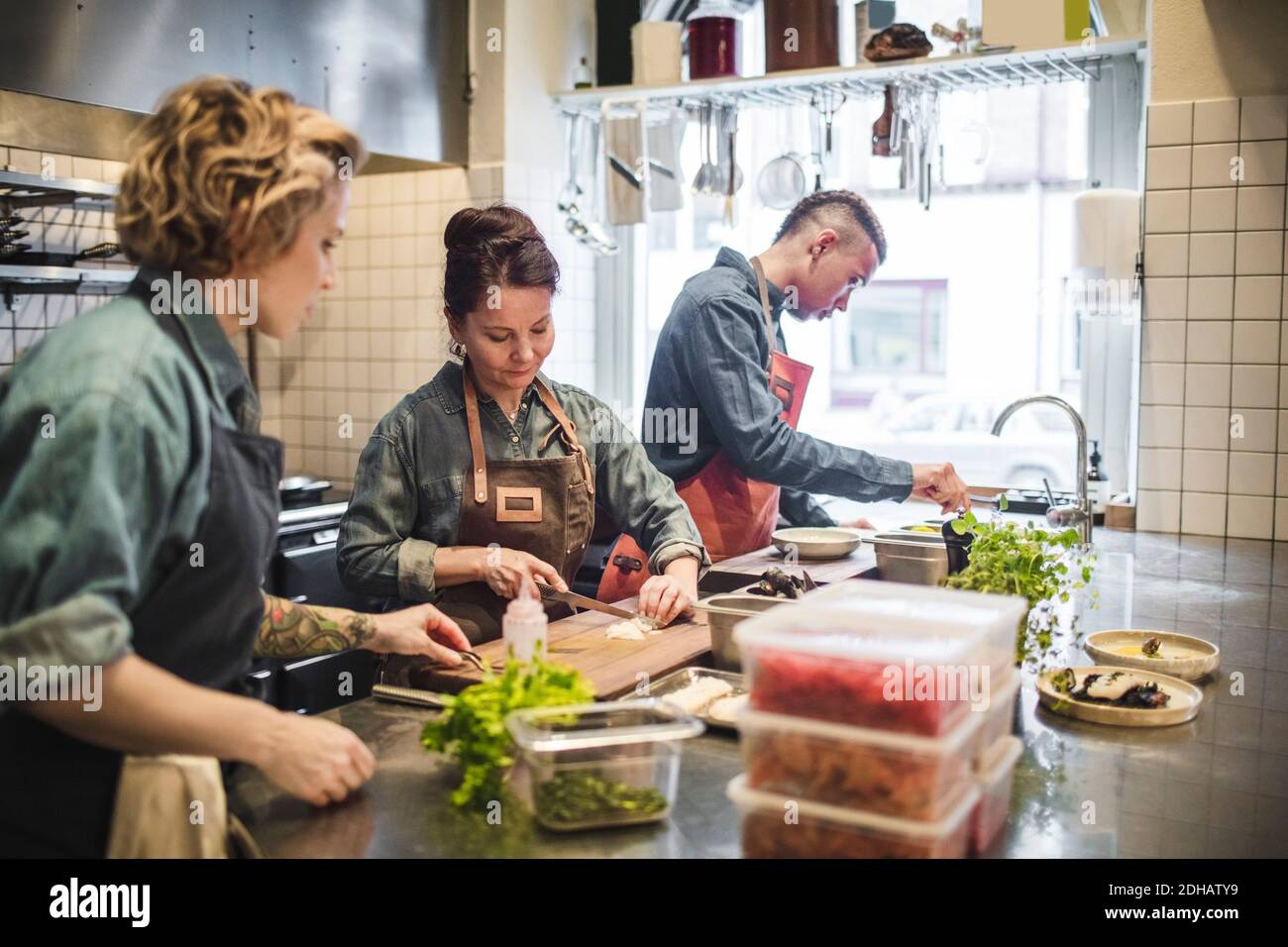 Multi-ethnic chefs preparing food at kitchen counter in restaurant ...